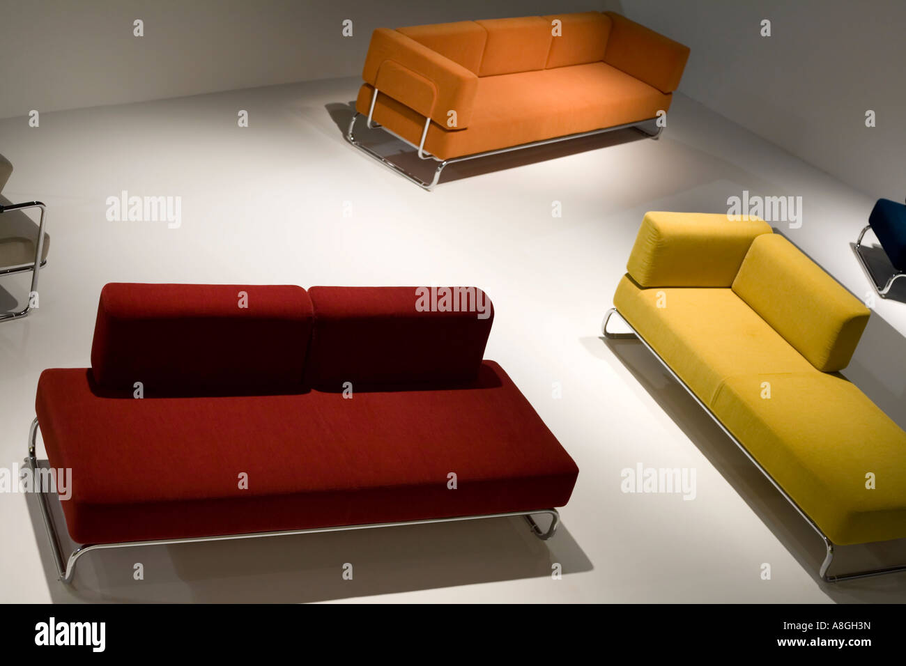 sofas in different colours on a diagonal wall Stock Photo - Alamy
