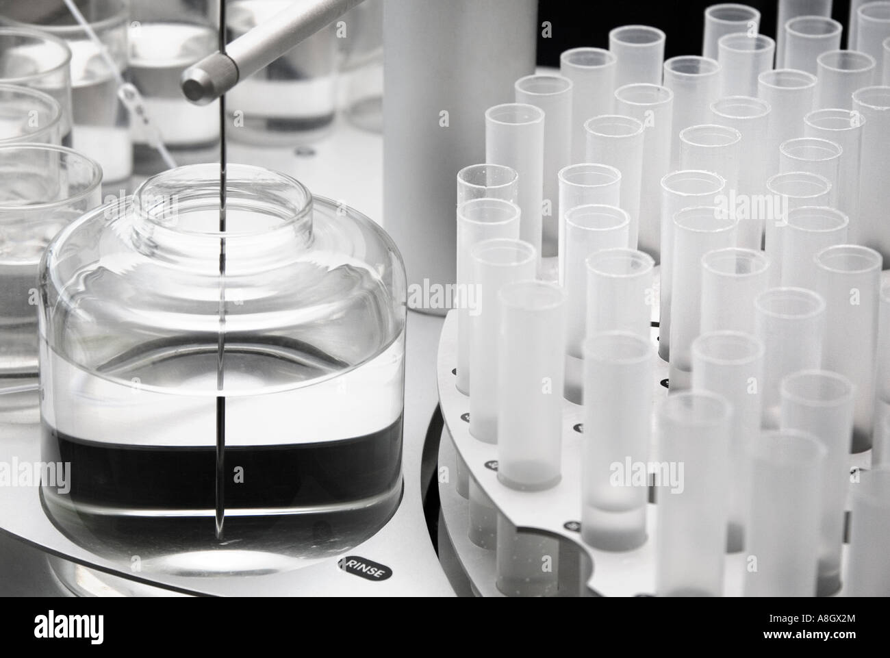 A needle descending into a clear glass bottle by a turnstile of test ...