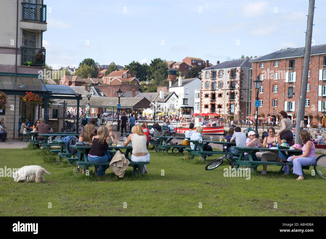 People relax at an outdoor cafe at The Quay, River Exe, Exeter, Devon ...