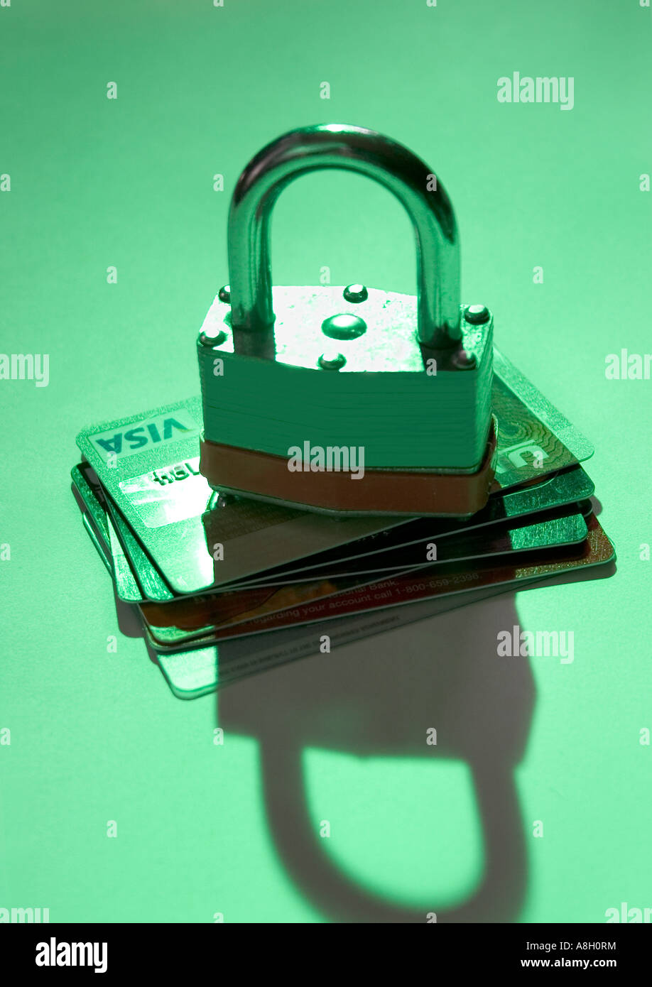 Stack of credit cards underneath a padlock. Credit card safety metaphor ...