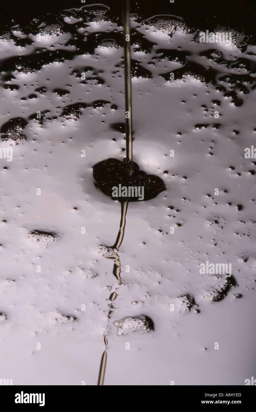 Stream of oil forming a black pool Stock Photo - Alamy