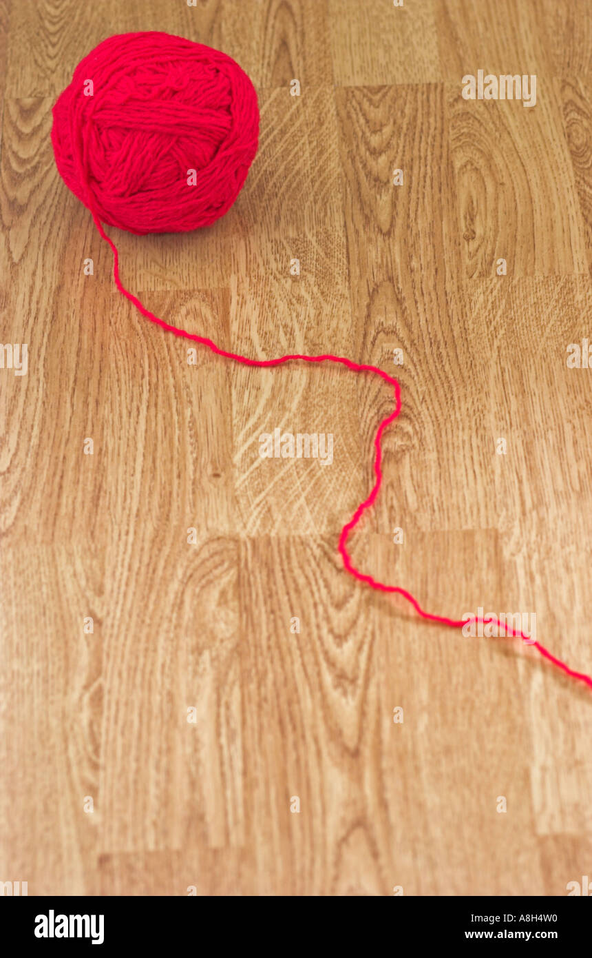 Ball of red wool on floor Stock Photo - Alamy