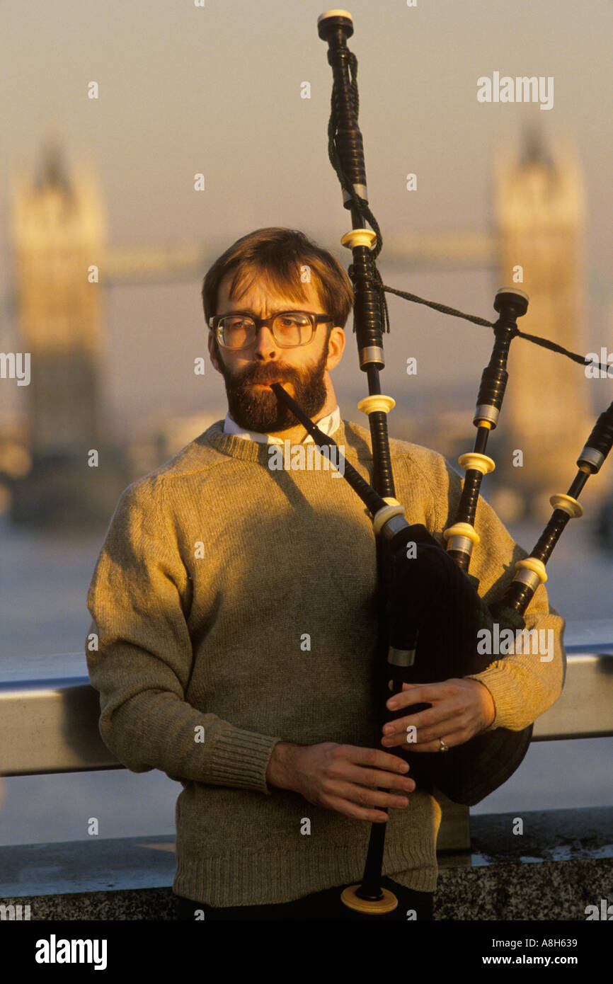 Busker playing bagpipes to collect money from office workers on London ...