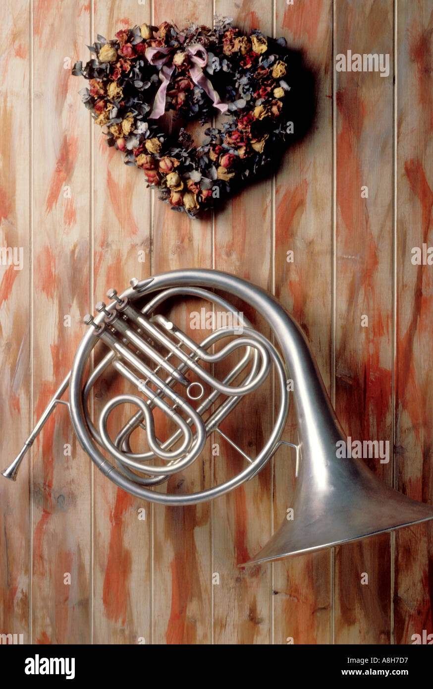 French horn hanging on wall with heart shaped wreath Stock Photo - Alamy