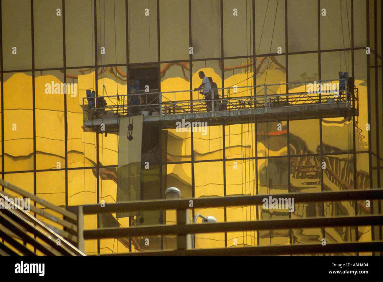 Men washing windows on a downtown building as sun rise lights the ...