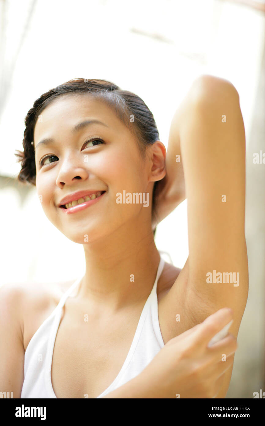 View of a young woman spraying deodorant on underarm Stock Photo - Alamy