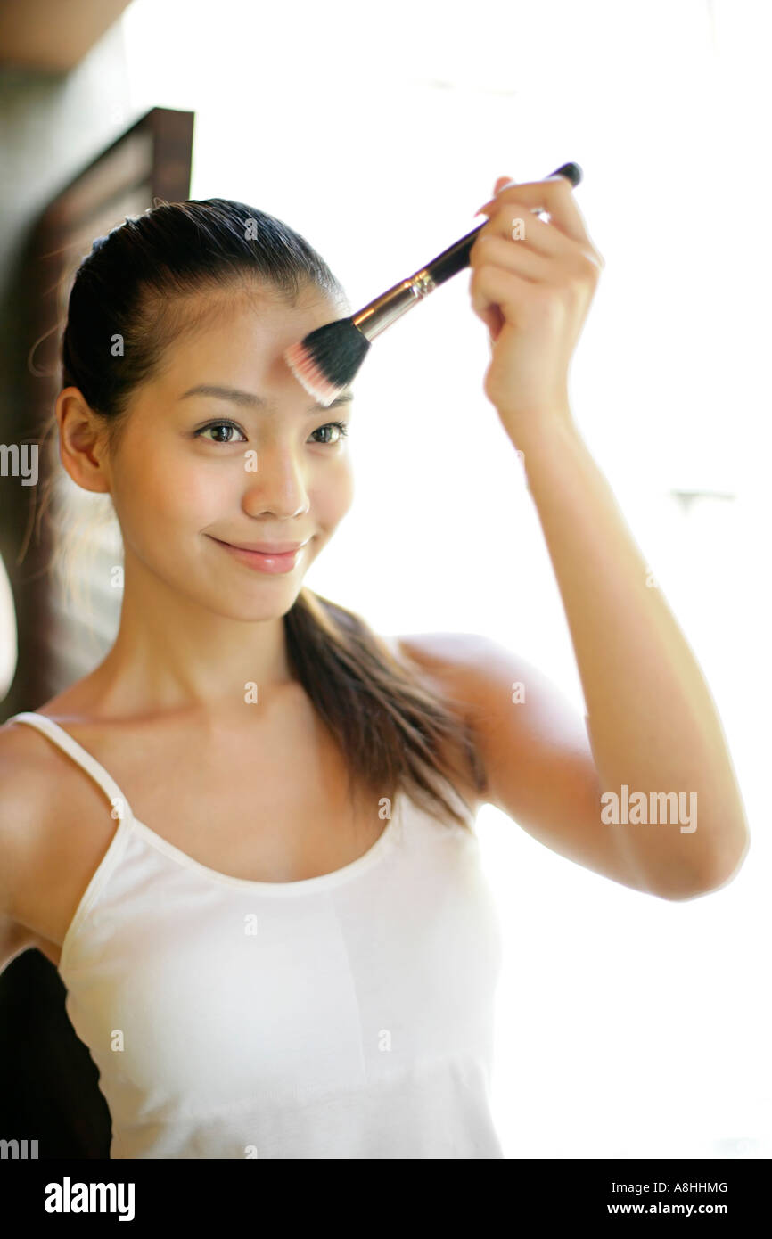 View of a young woman applying a foundation on forehead Stock Photo - Alamy