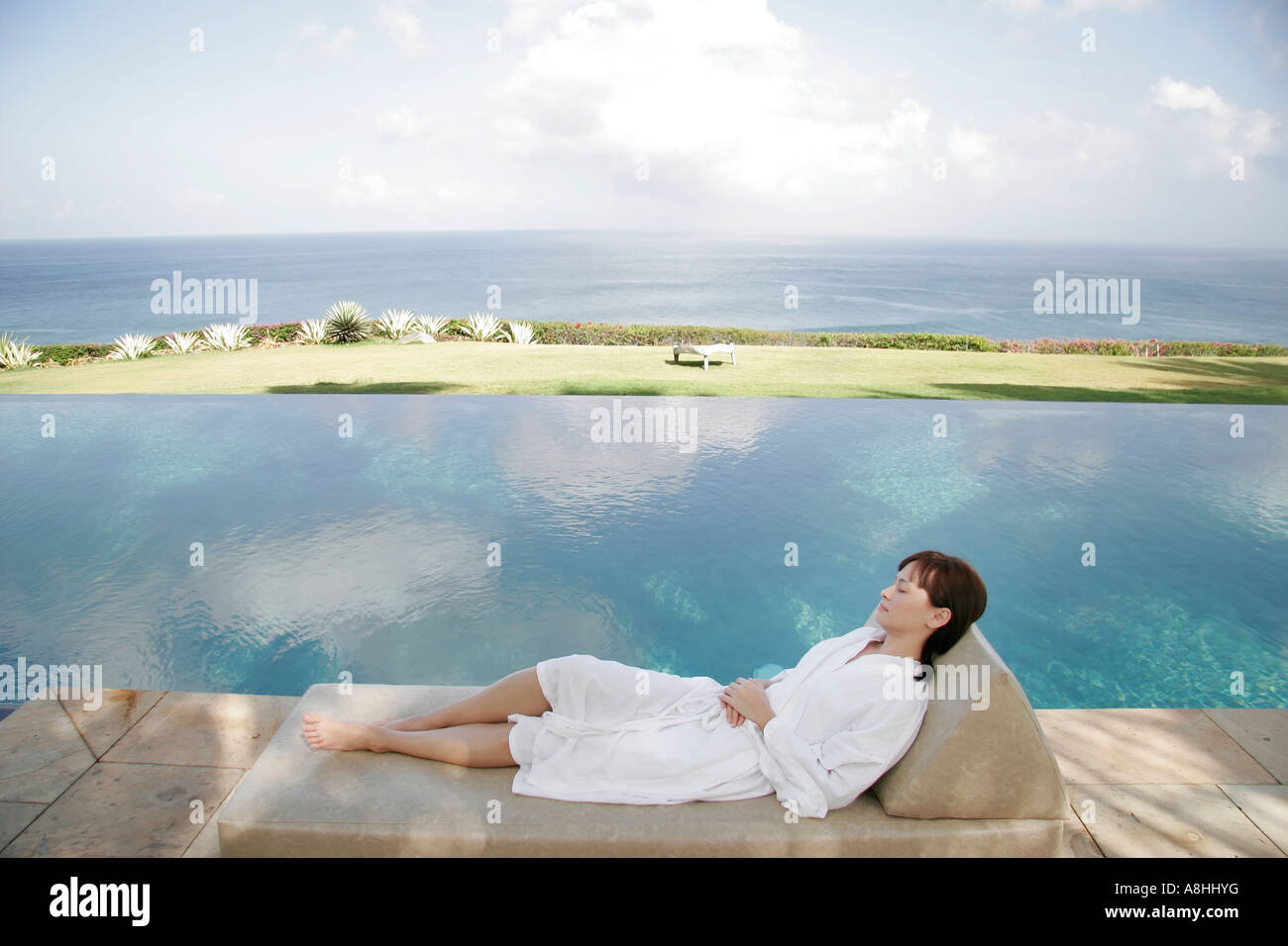 Young woman lying besides a swimming pool Stock Photo - Alamy