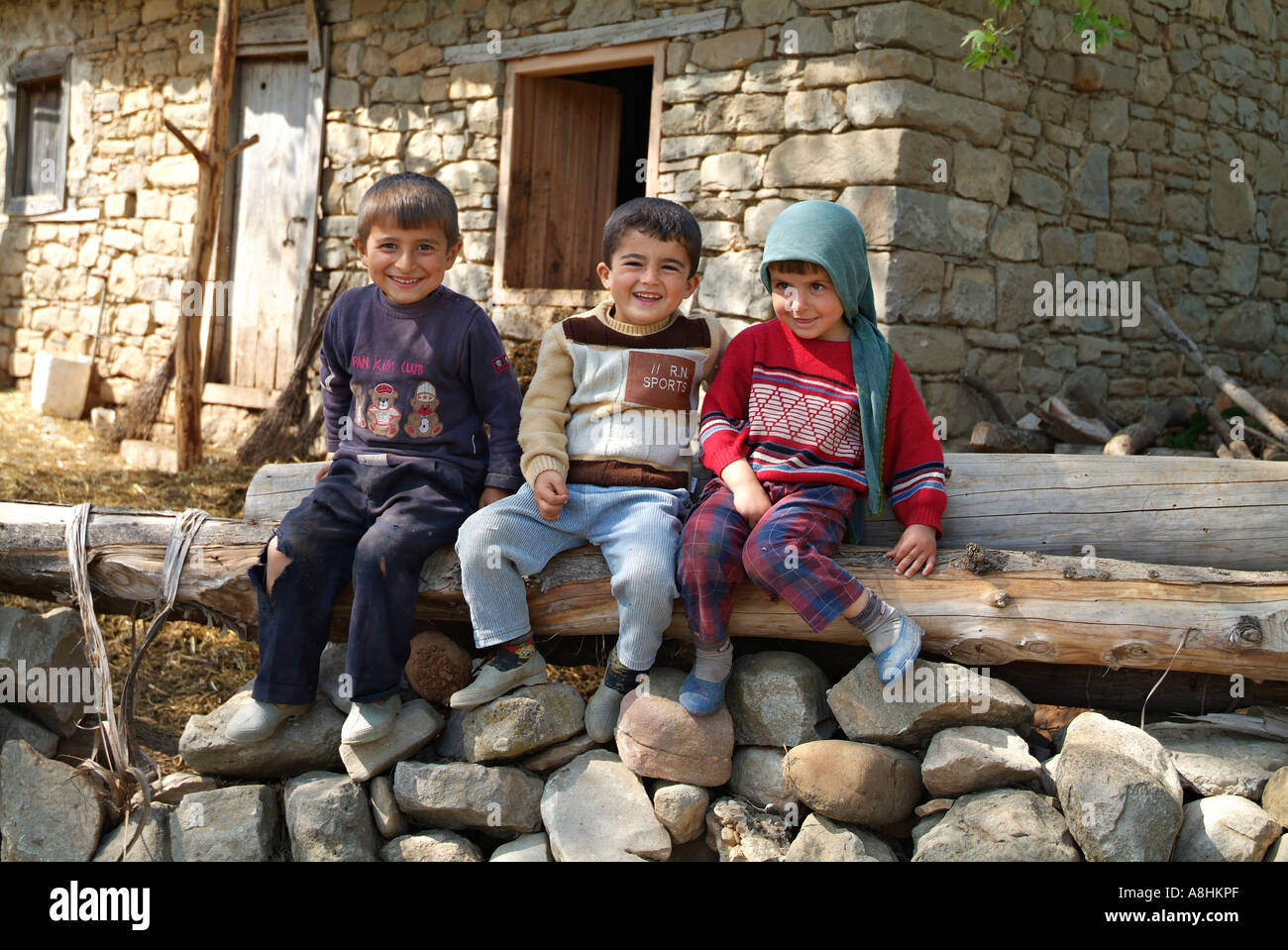 Turkish villagers Group of children seated on a stone wall in a rural ...