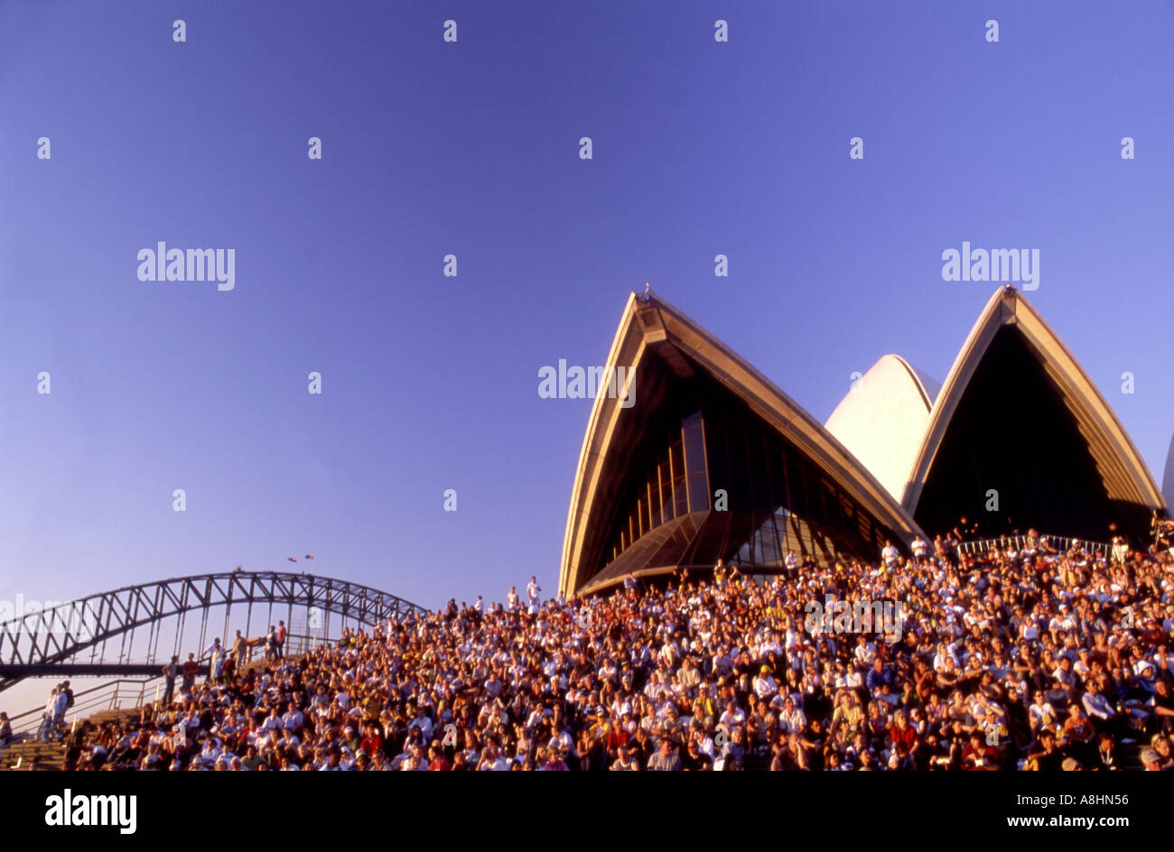 Sydney Opera House and steps with crowds seated foreground Harbour ...