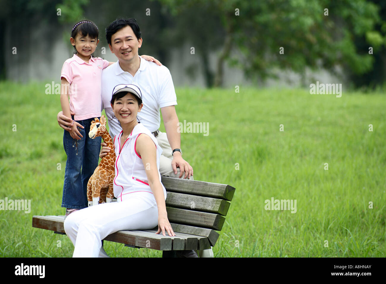 View of a family sitting on the bench Stock Photo - Alamy