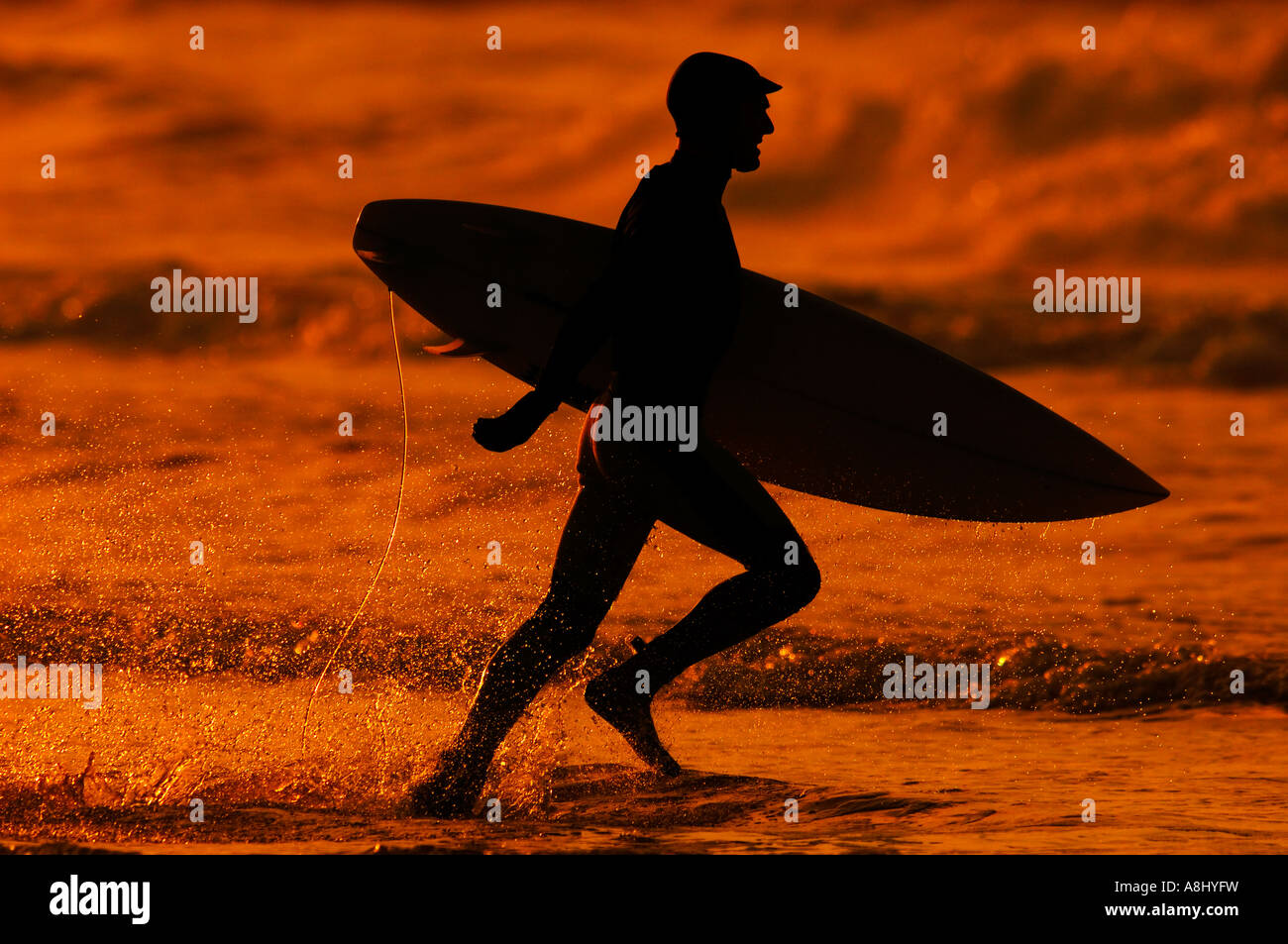 Running Surfer men on the beach with surfboard and gold light ...