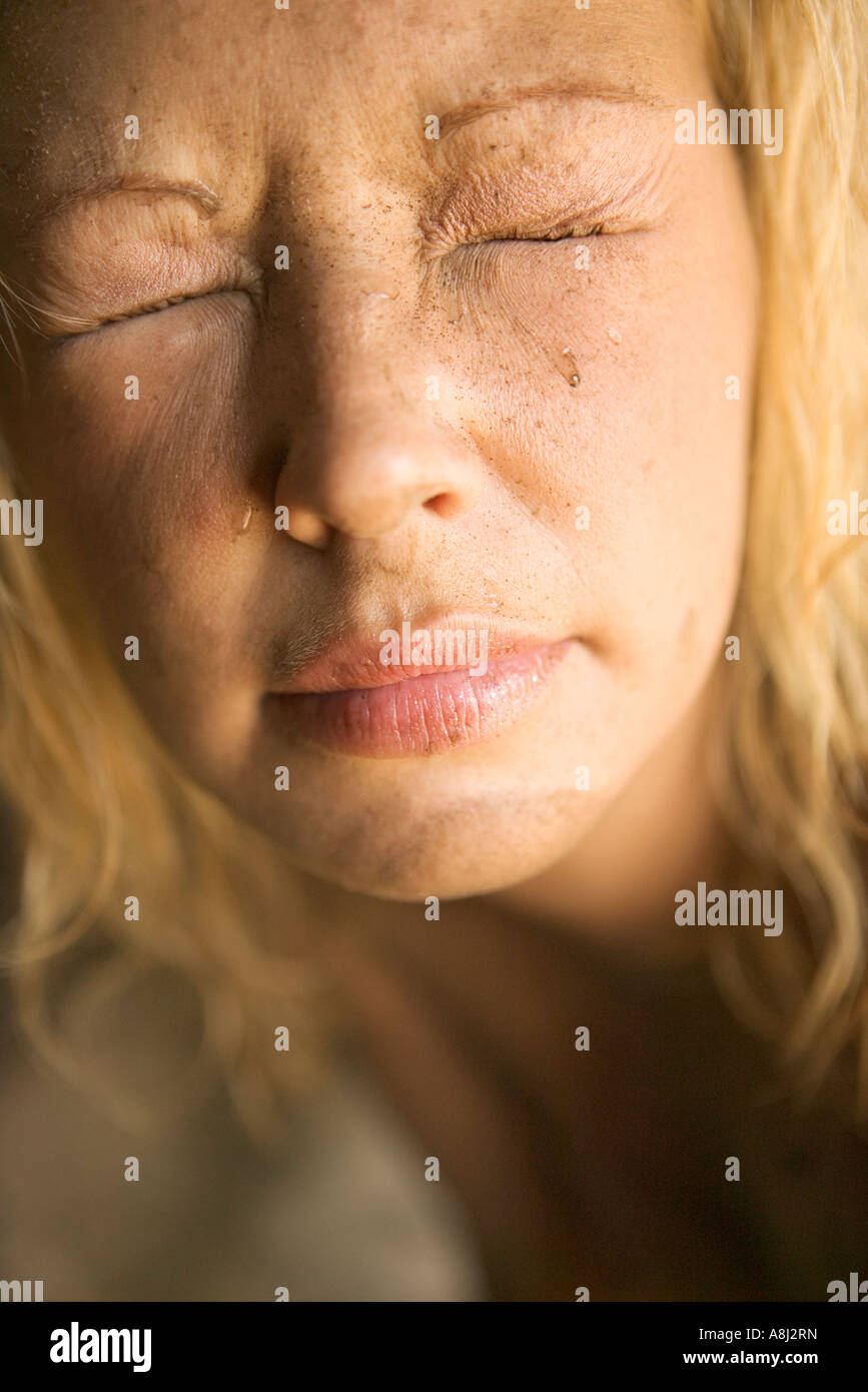 Close up of blond womans muddy face with closed squinting eyes Stock ...