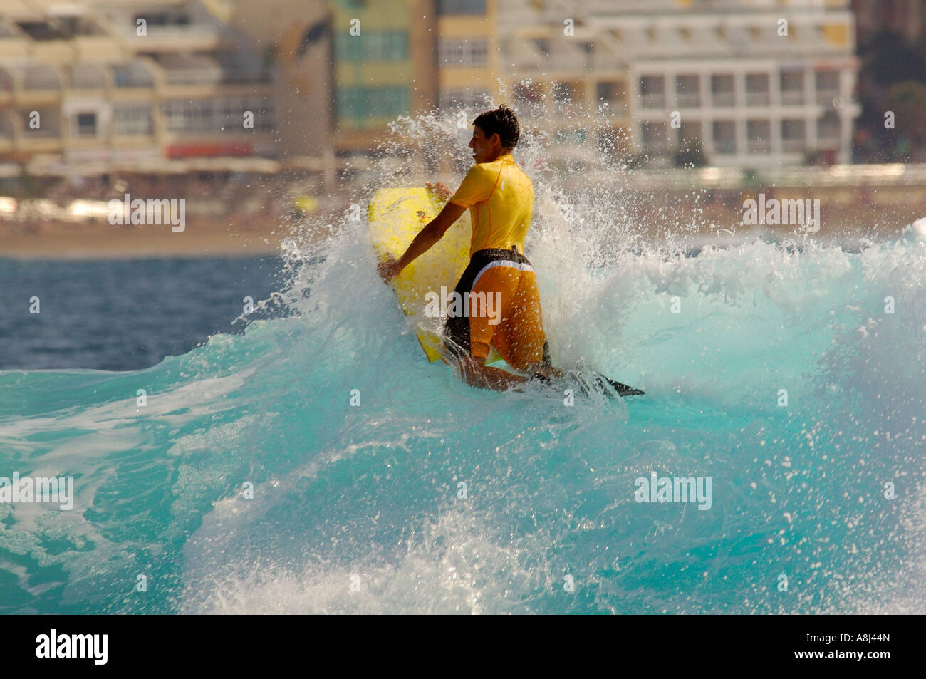 Men boogie boarding bodybording on the sea Gran Ganaria 2006 with city ...