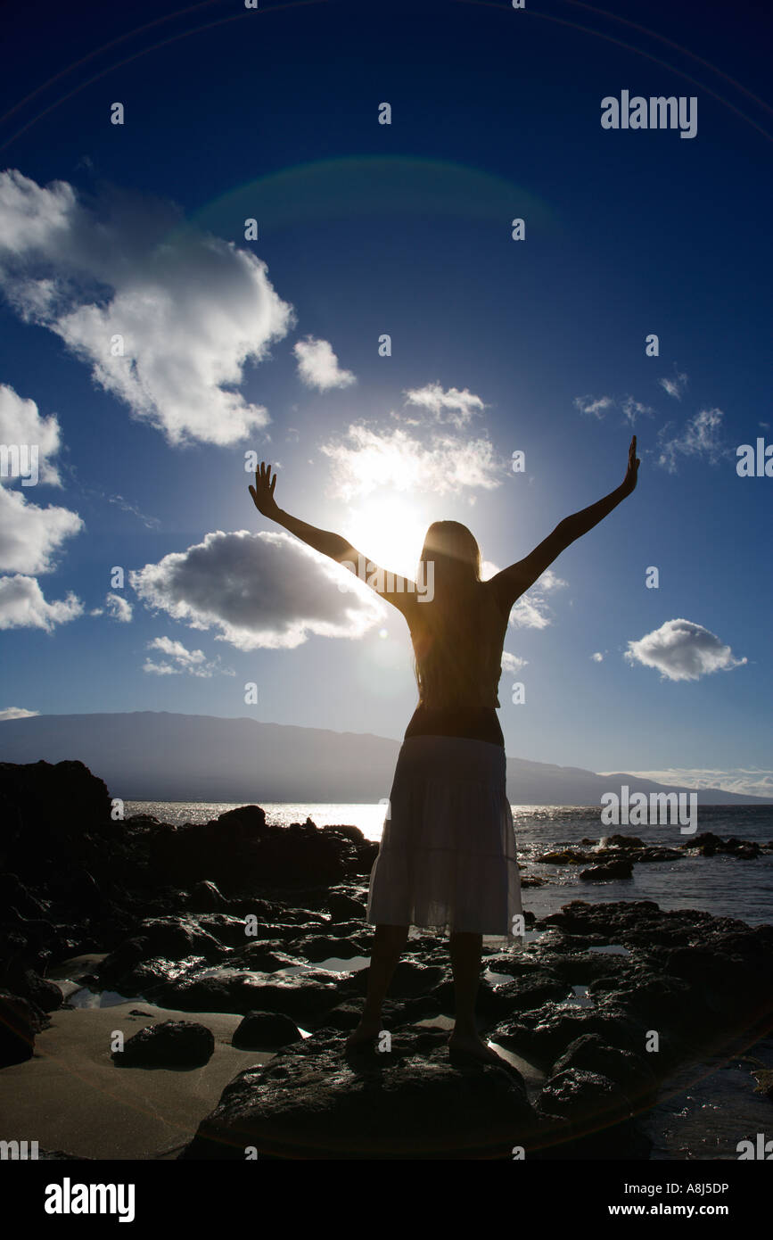 Young adult Asian Filipino female stretching arms in air on beach in ...