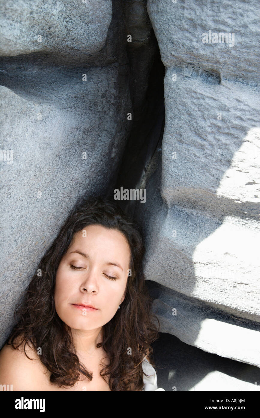 Portrait of brunette Caucasian mid adult woman by rock formation with ...
