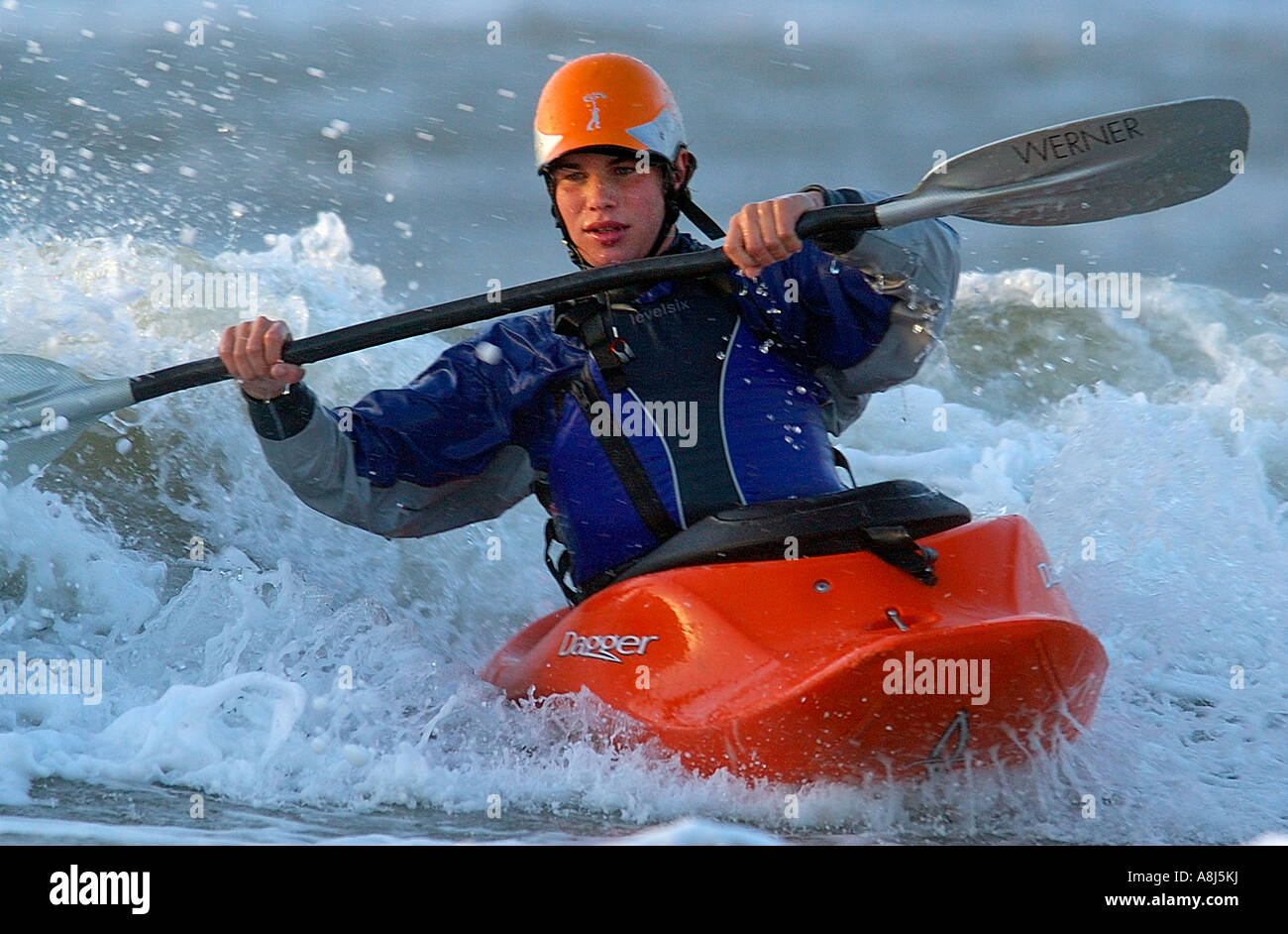 Kayak men in action with orange helmet place the Nort Sea Scheveningen ...
