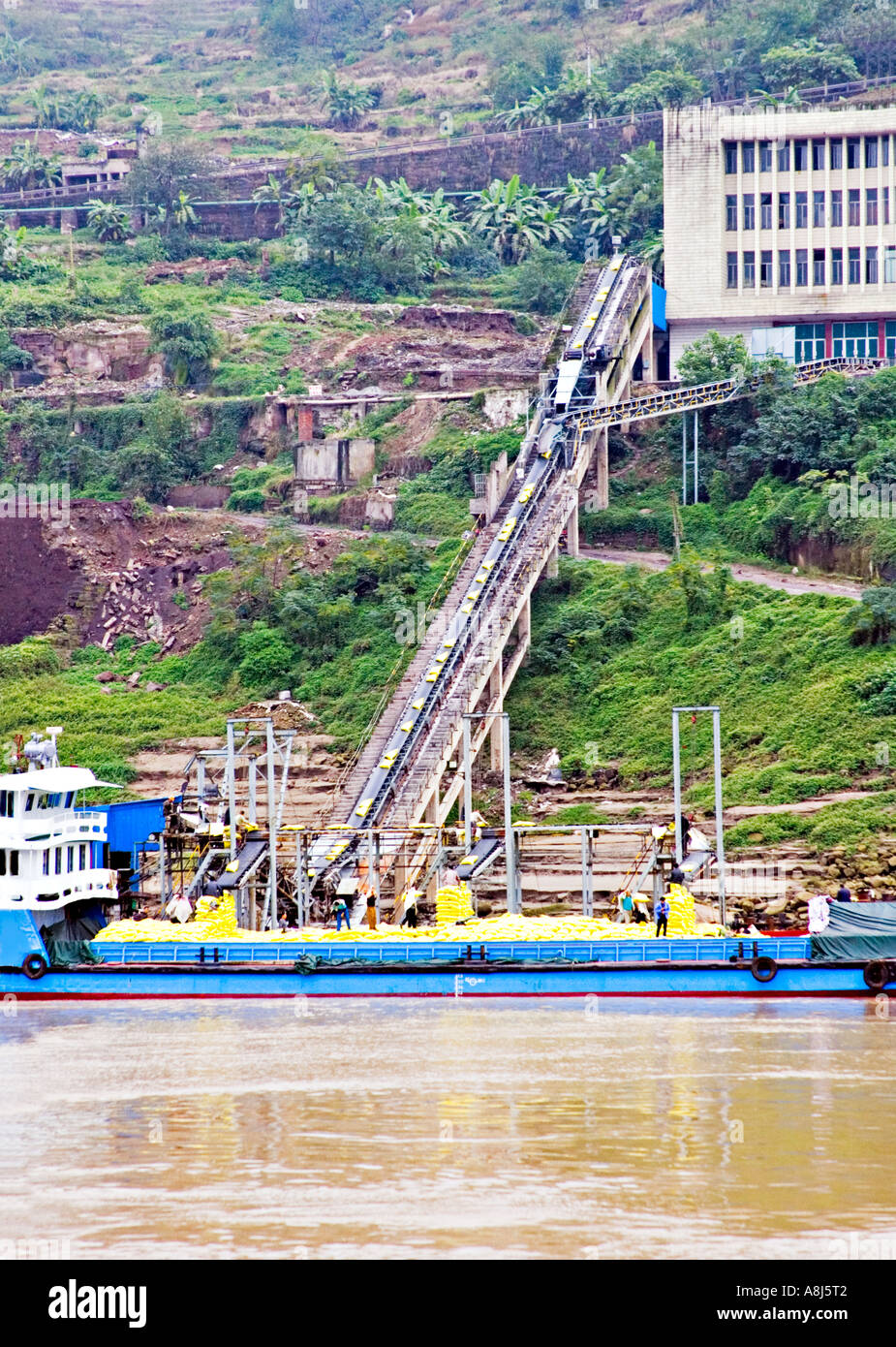 CHINA YANGTZE RIVER Chinese workers load barges with yellow bags of ...