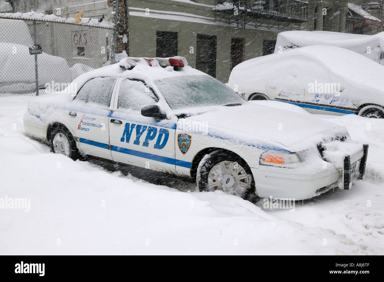 An NYPD cruiser sits covered in snow during a storm in New York City ...