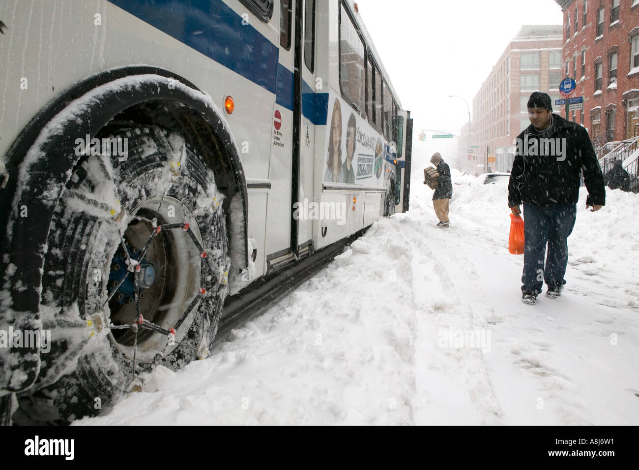 An MTA bus equipped with chains picks up passengers during a snow storm ...