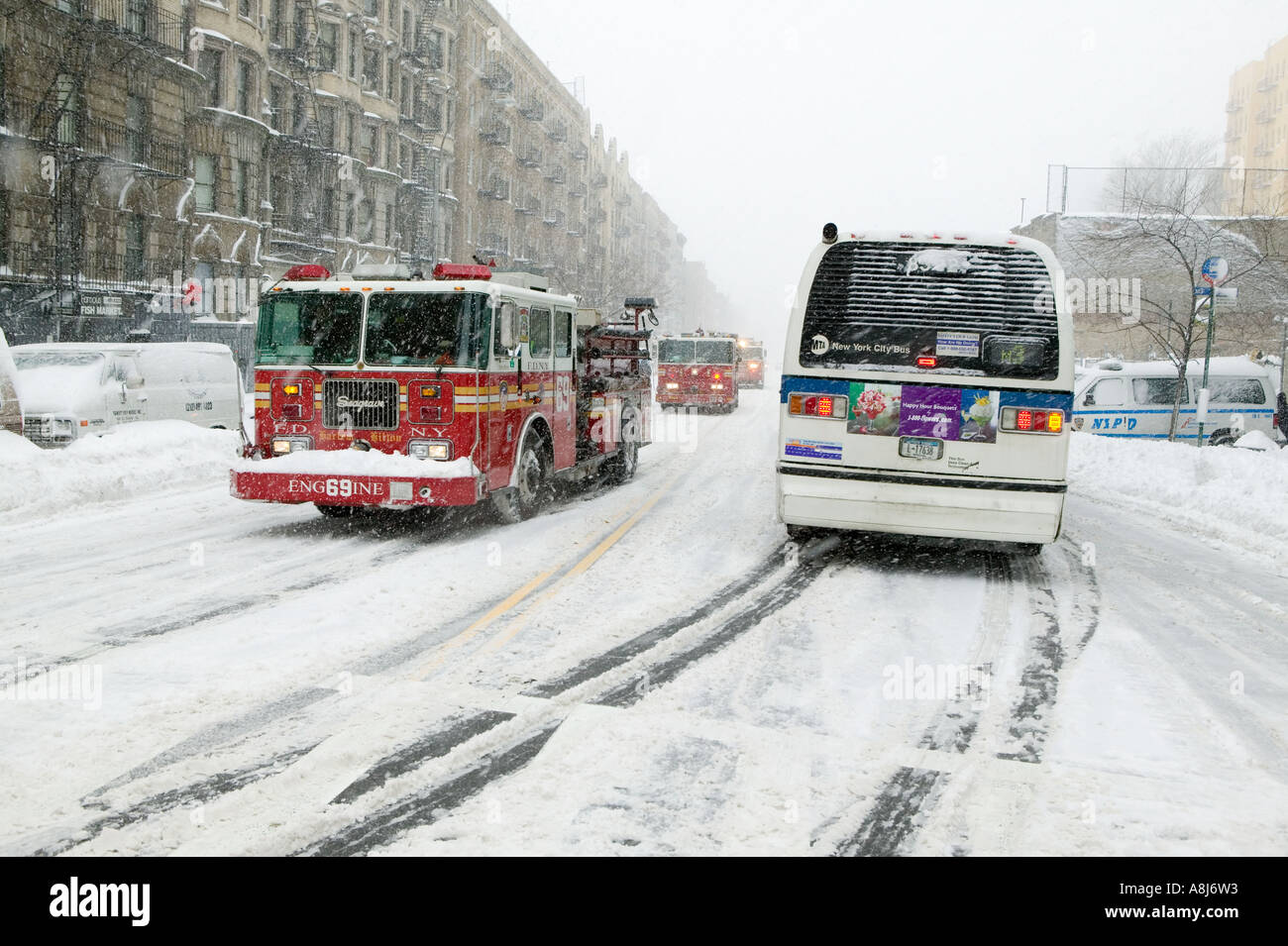 Red FDNY fire trucks drive through a snow storm in Harlem New York City ...
