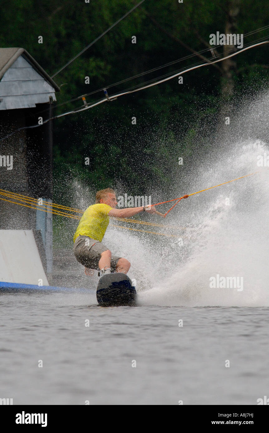 People Wakeboarding on lake boy make big spray with background with ...