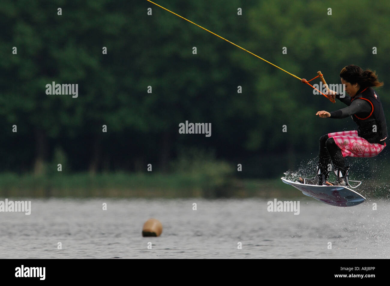 Wakeboarding girl far shot on the flat water 2006 with background Stock ...