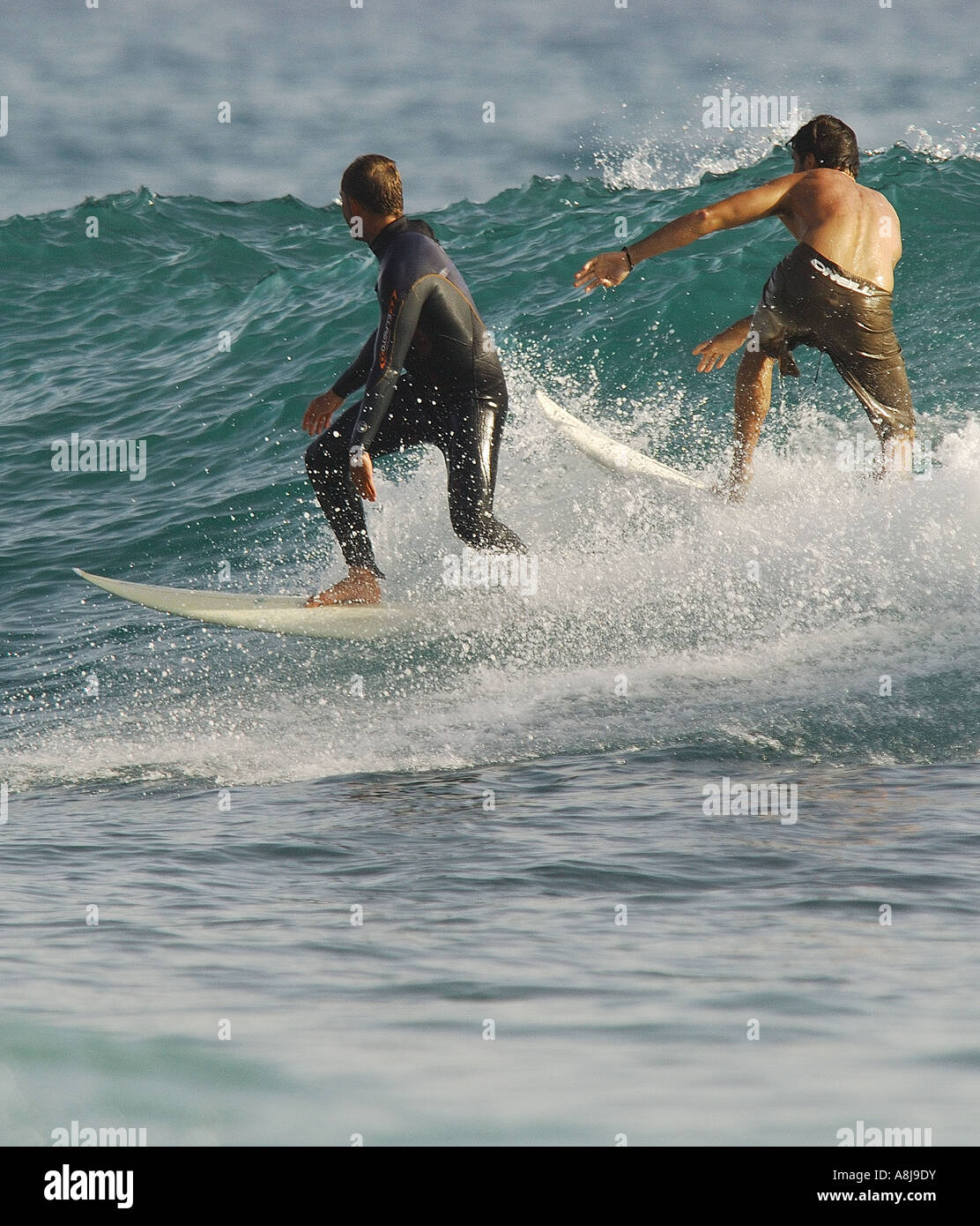Two surf men for one wave Stock Photo - Alamy