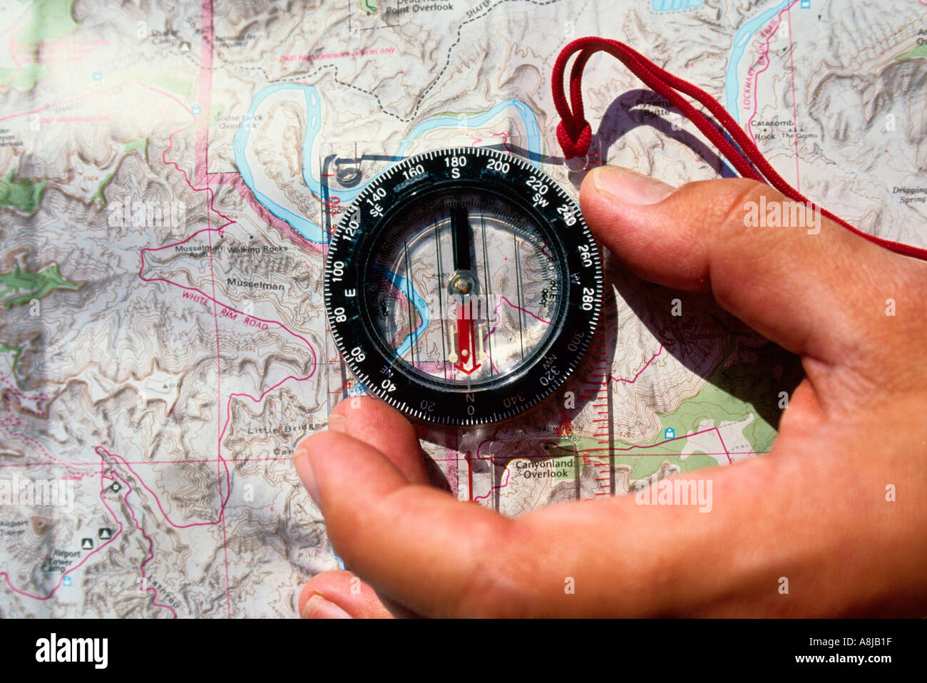 a man using a compass on a map to navigate Stock Photo - Alamy