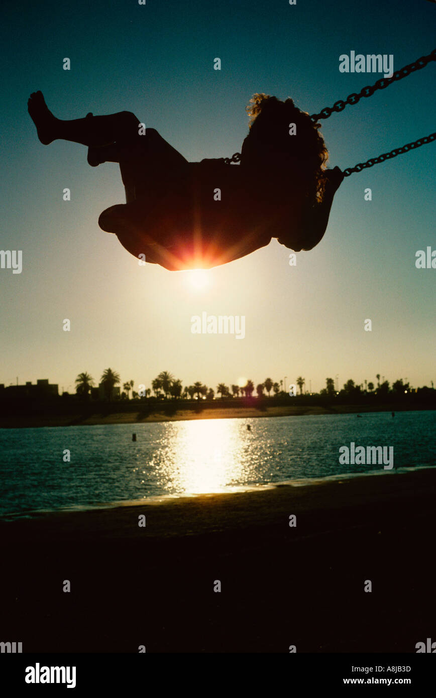 Children playing on swing sunset hi-res stock photography and images ...