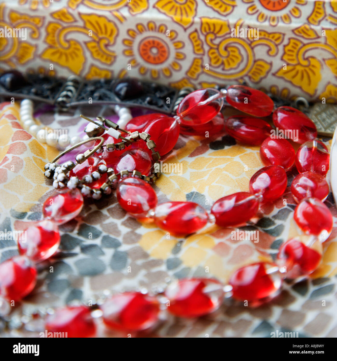Close up of red bead necklace against pattern mosaic Stock Photo - Alamy