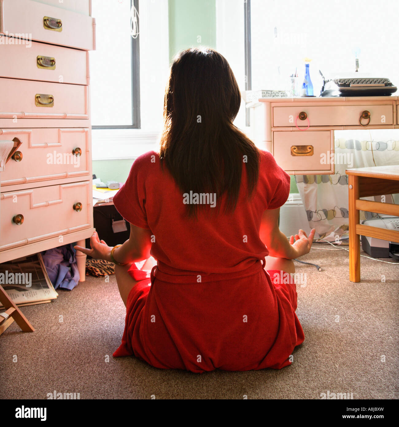Back view of pretty Asian young woman in red robe sitting on floor ...