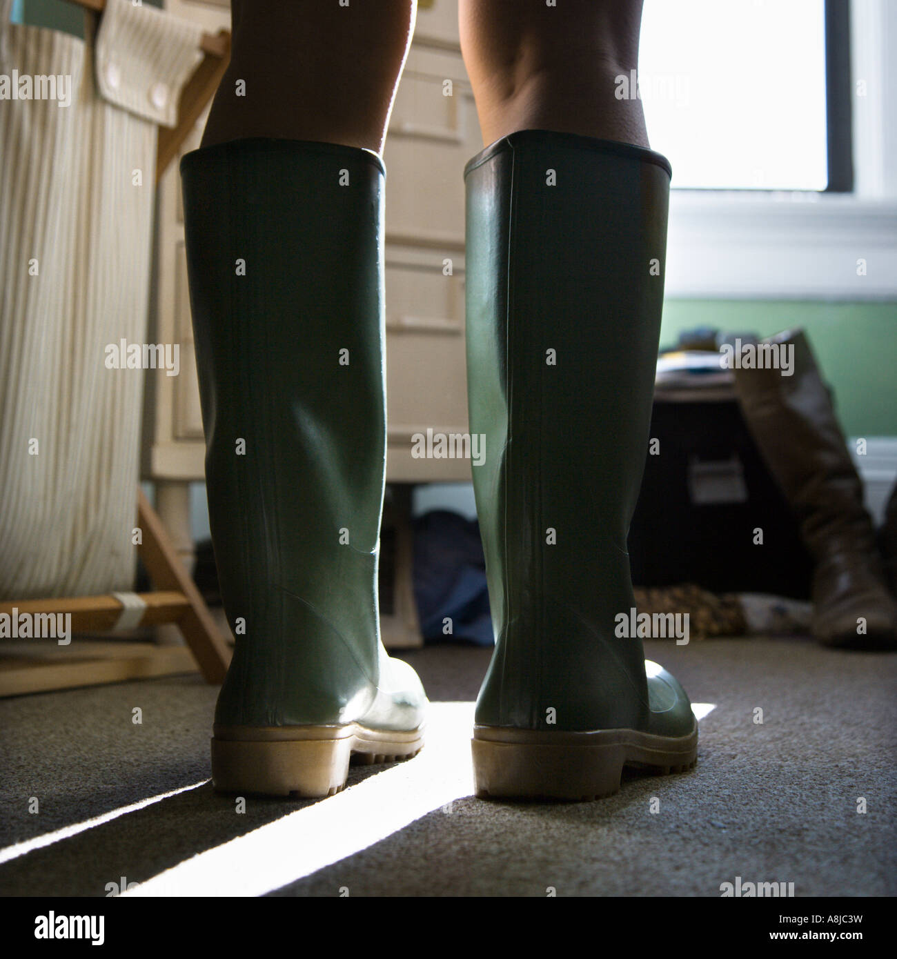 Low angle of woman s legs wearing green rubber boots Stock Photo - Alamy