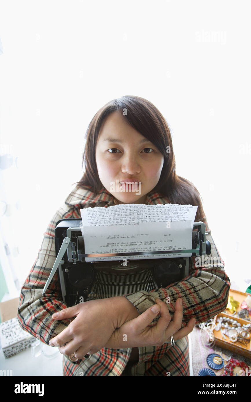 Pretty young Asian woman holding typewriter Stock Photo - Alamy