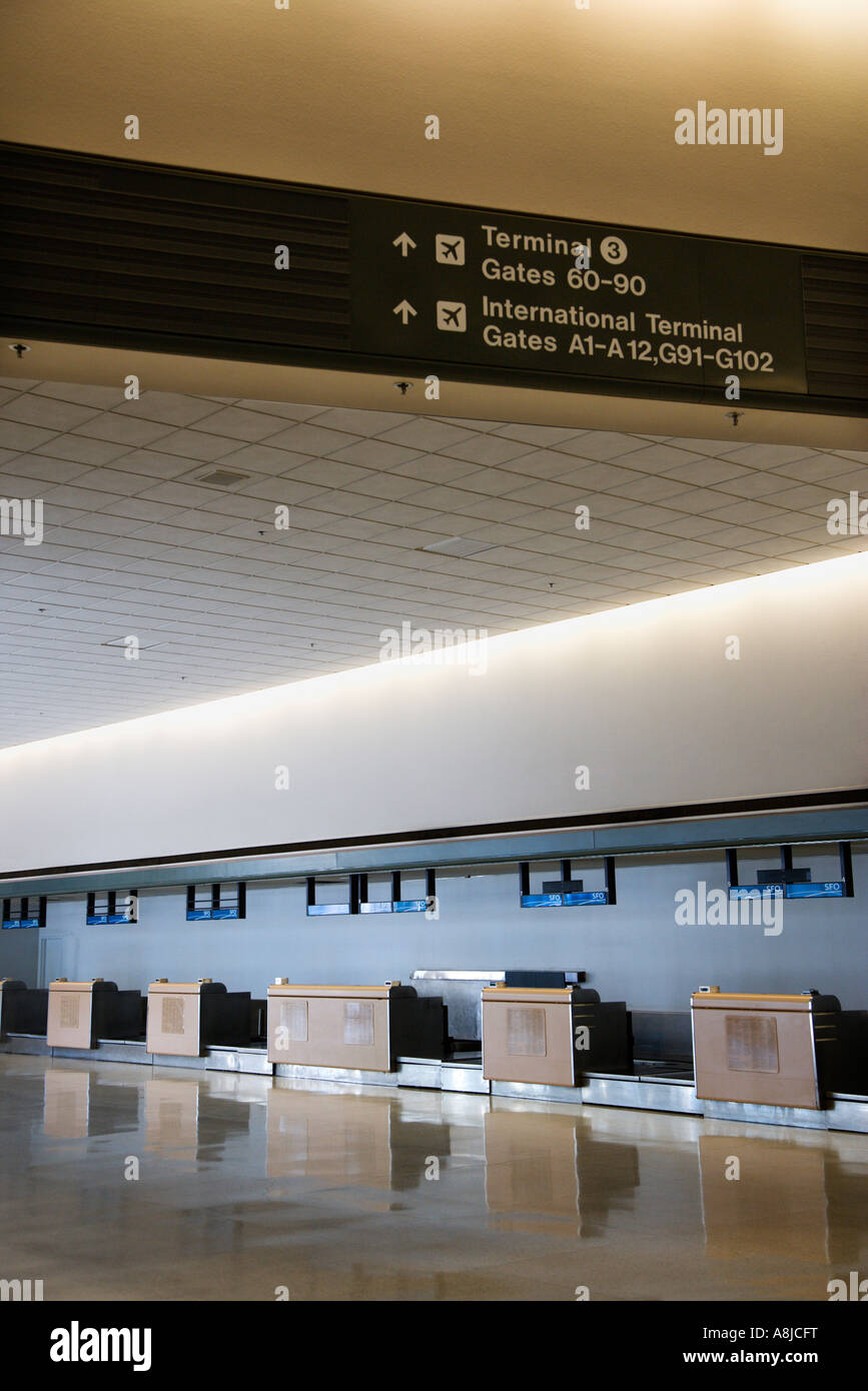 Signs for terminal and gates with empty check in station in background ...
