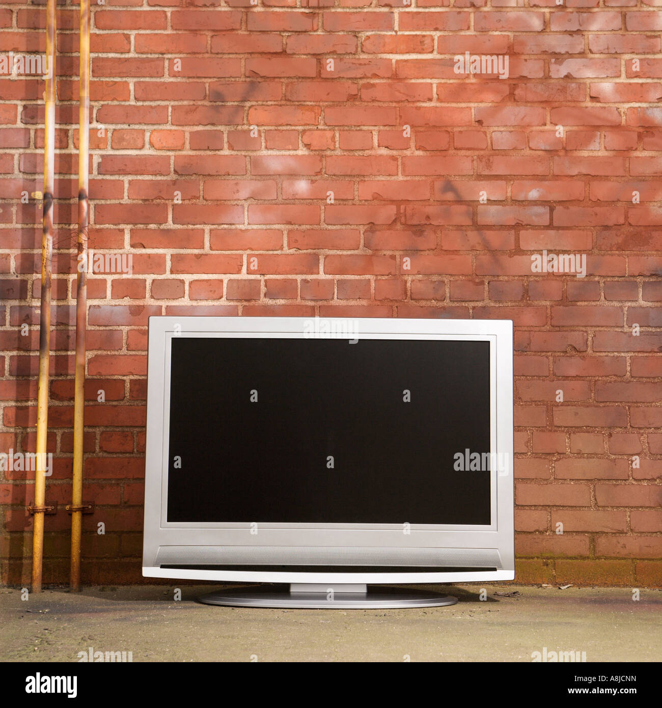 Flat panel television set in front of red brick wall Stock Photo - Alamy