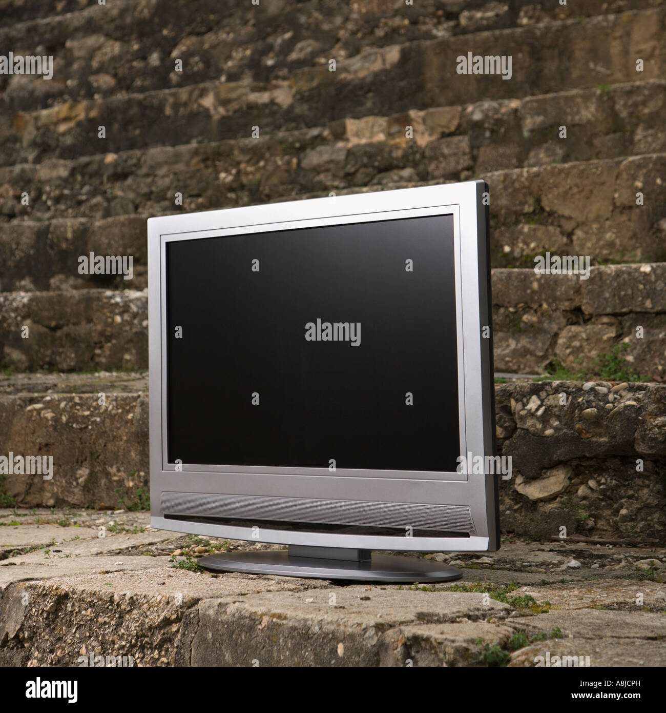 Flat panel television set in front of gray brick wall Stock Photo - Alamy