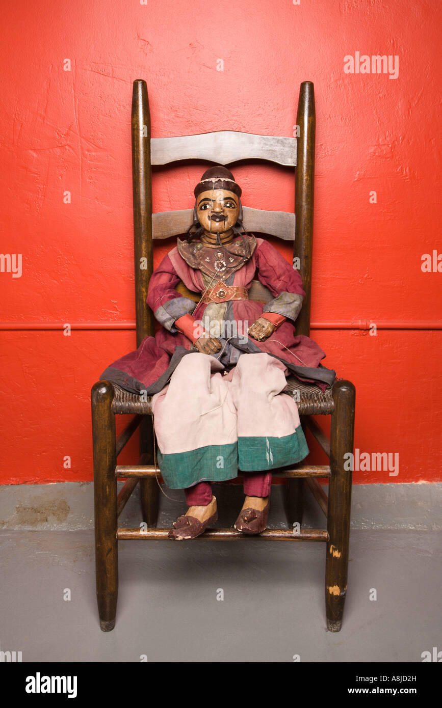 Wooden puppet sitting on chair Stock Photo - Alamy
