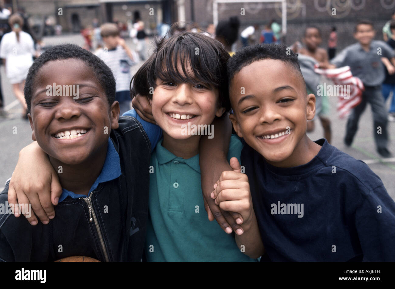 three primary school friends smile to camera Stock Photo - Alamy