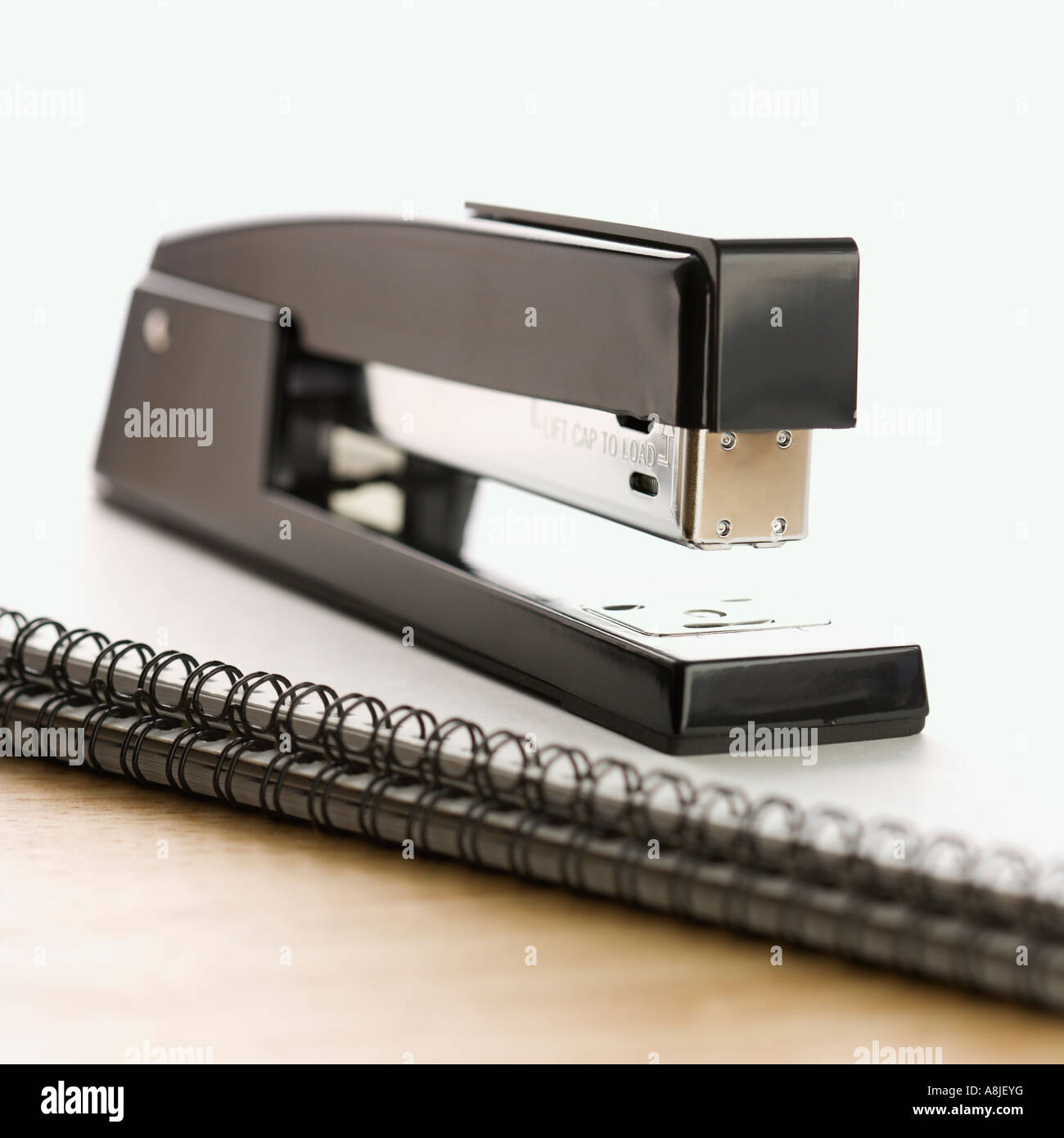 Black stapler on top of a spiral bound notebook Stock Photo - Alamy