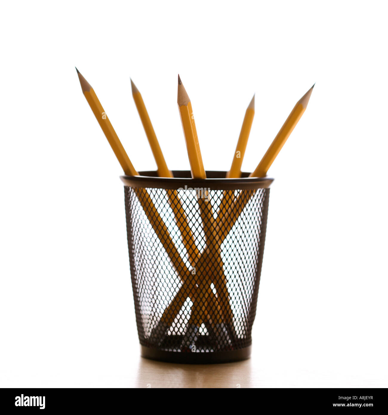 Five pencils in a wire mesh pencil holder Stock Photo - Alamy