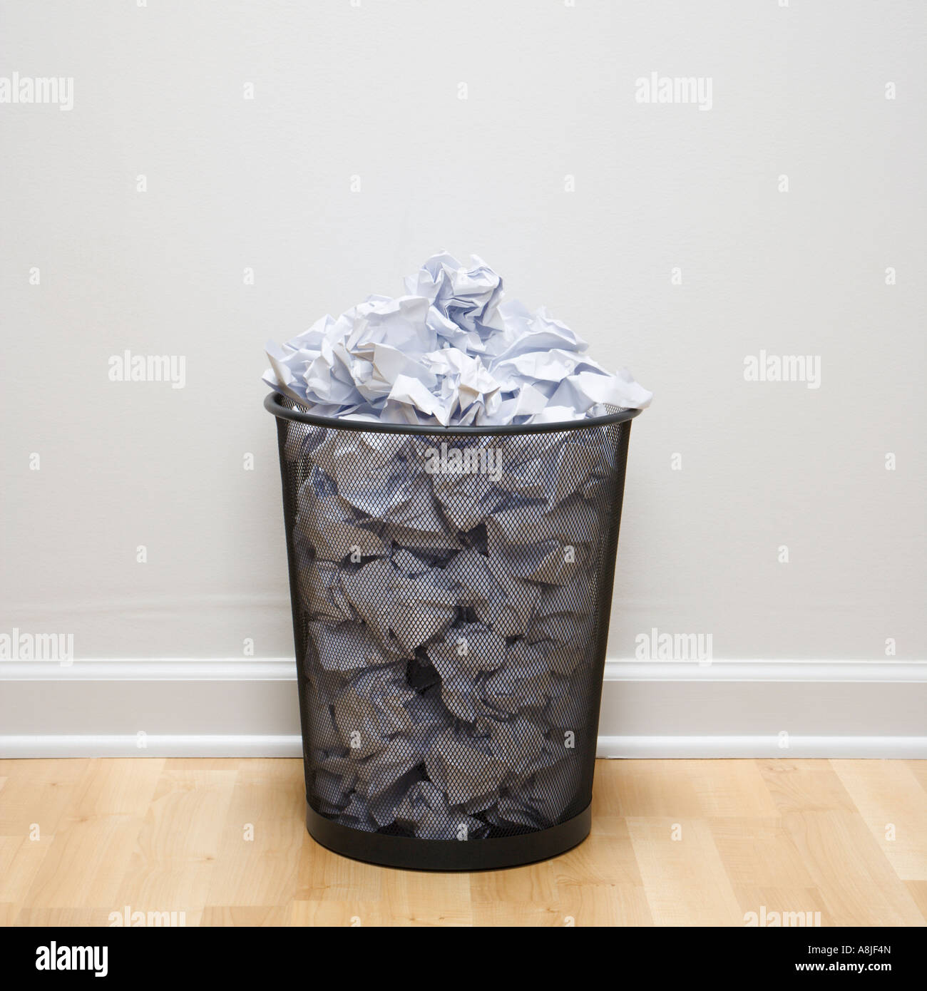 Wire mesh trash can filled with crumpled paper Stock Photo - Alamy
