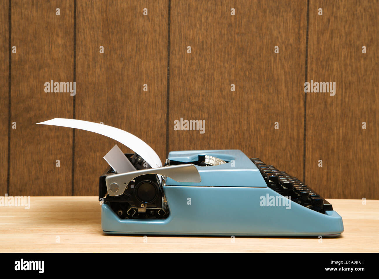 Vintage blue typewriter on desk with wood paneling Stock Photo - Alamy