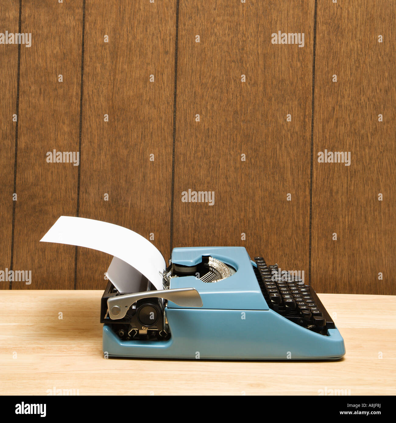 Vintage blue typewriter on desk with wood paneling Stock Photo - Alamy