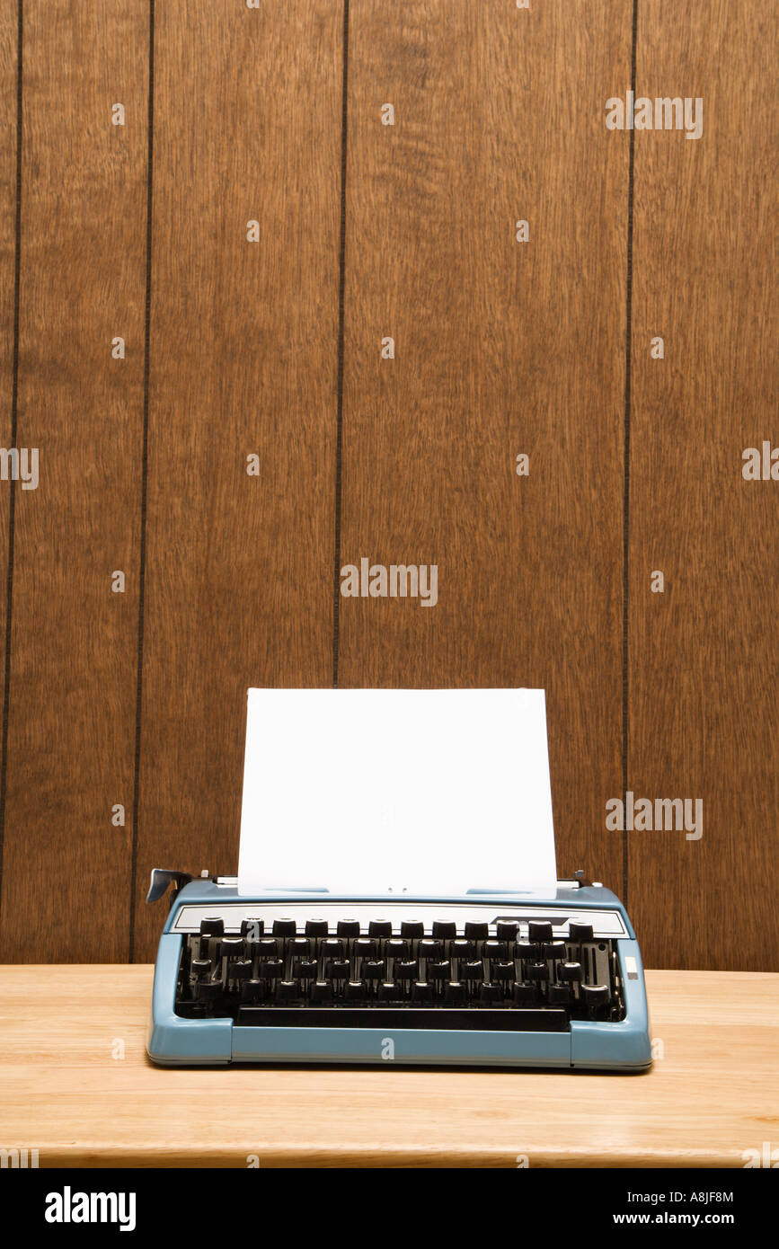Vintage blue typewriter on desk with wood paneling Stock Photo - Alamy