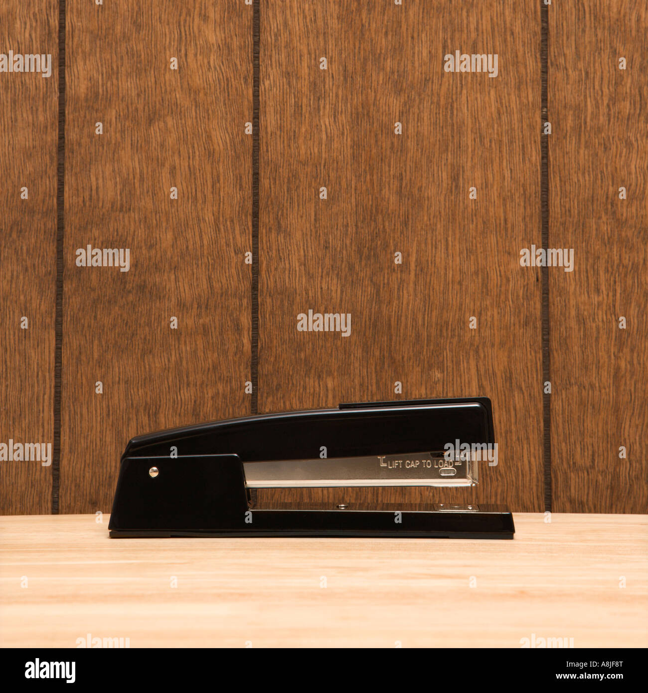 Black stapler on desk with wooden paneling Stock Photo - Alamy