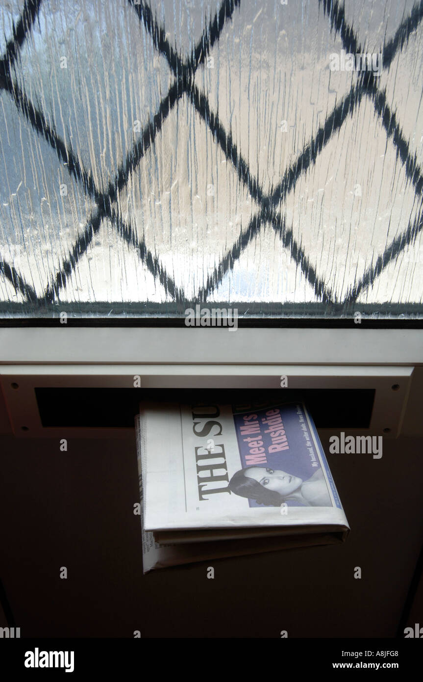 Newspaper in letterbox Stock Photo - Alamy