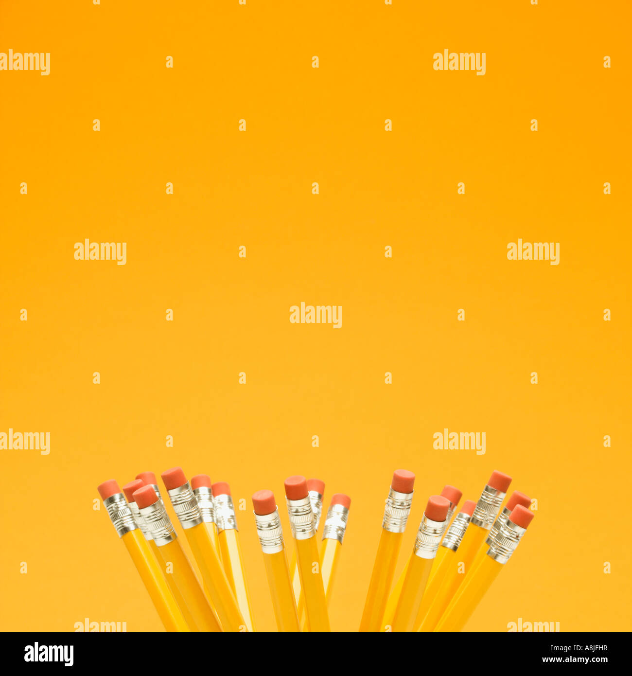 Group of eraser ends of pencils on orange background Stock Photo - Alamy