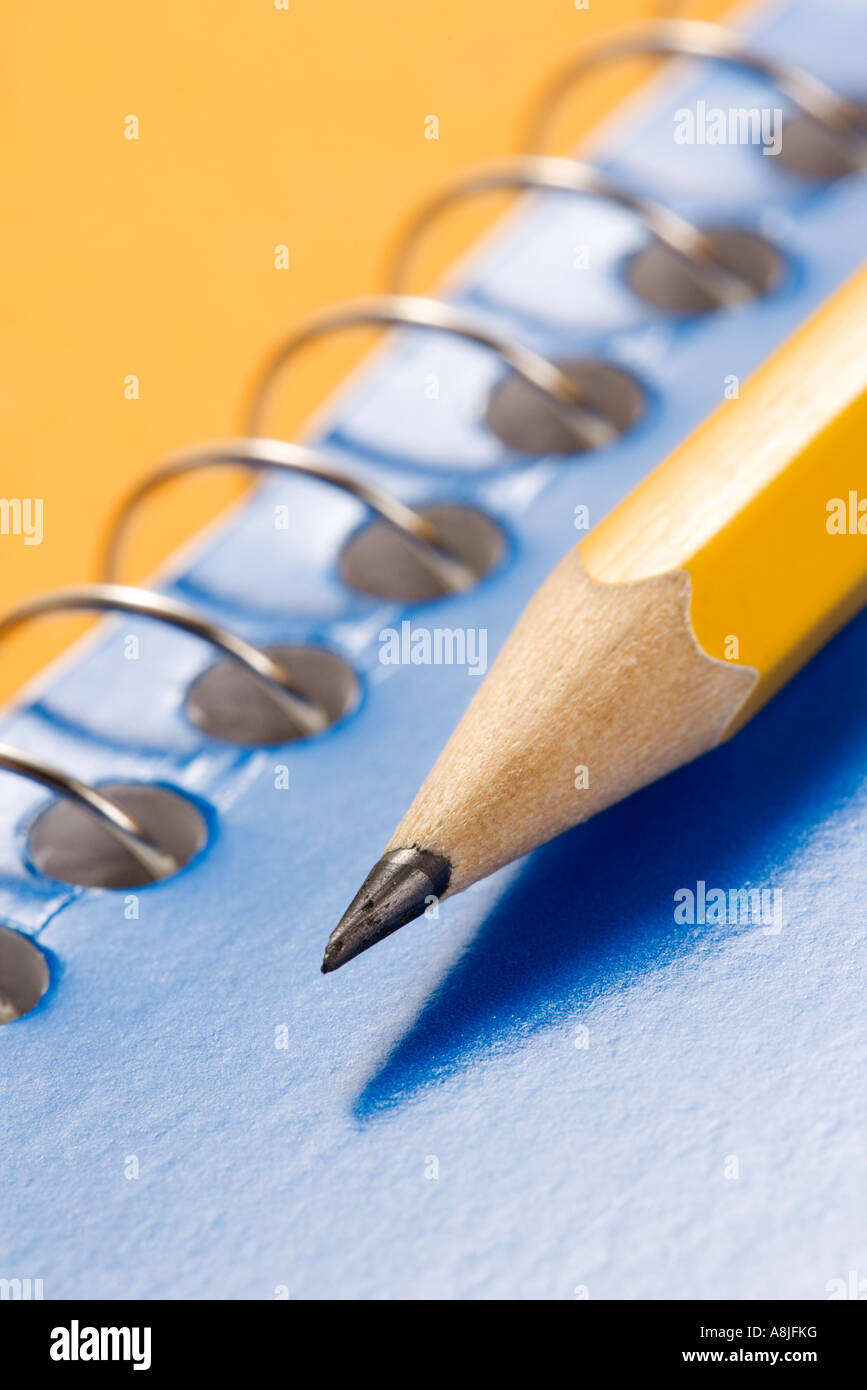 Close up of sharp pencil placed on blue spiral bound notebook Stock ...