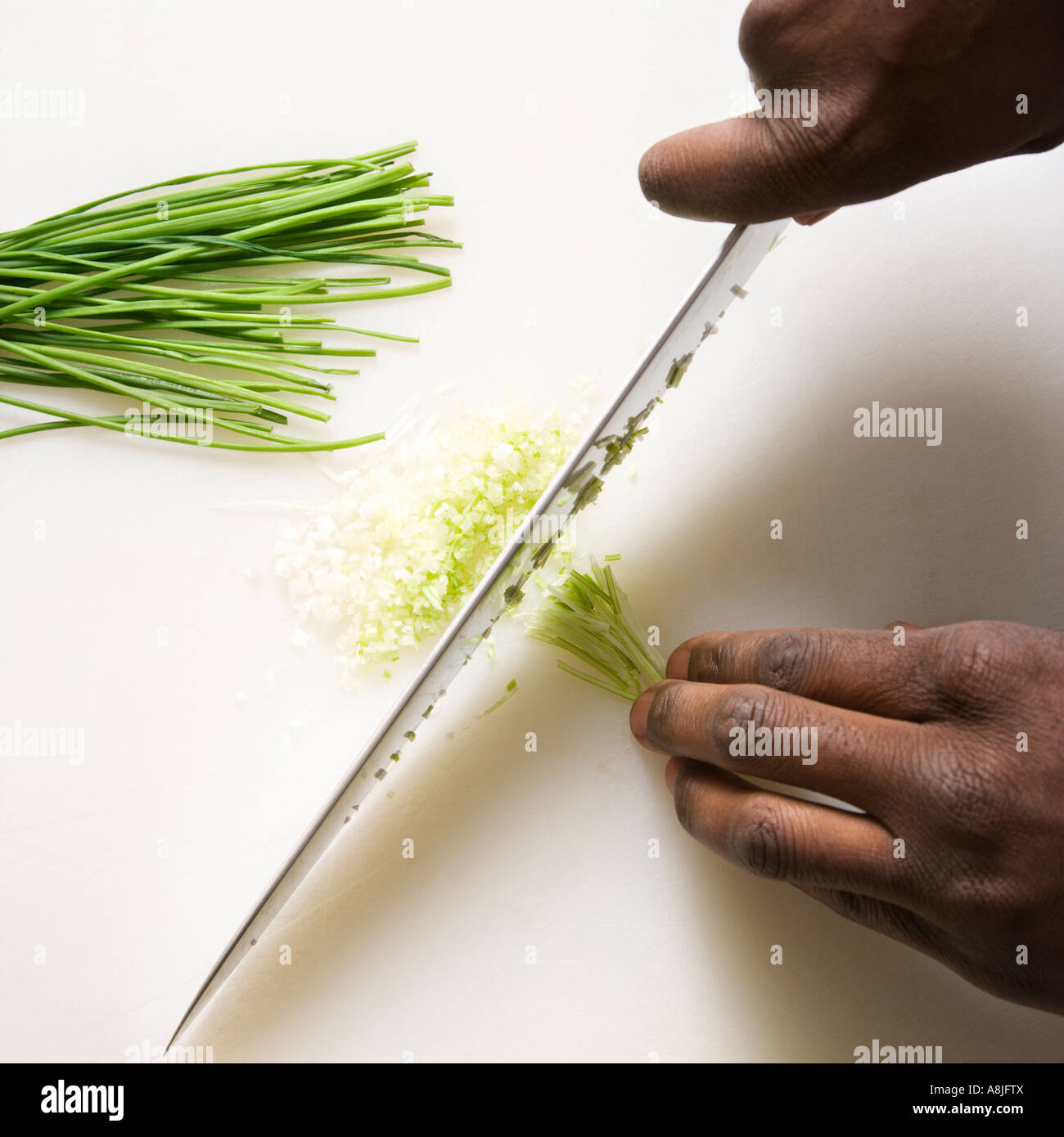 African American male hands using large kitchen knife to chop fresh ...